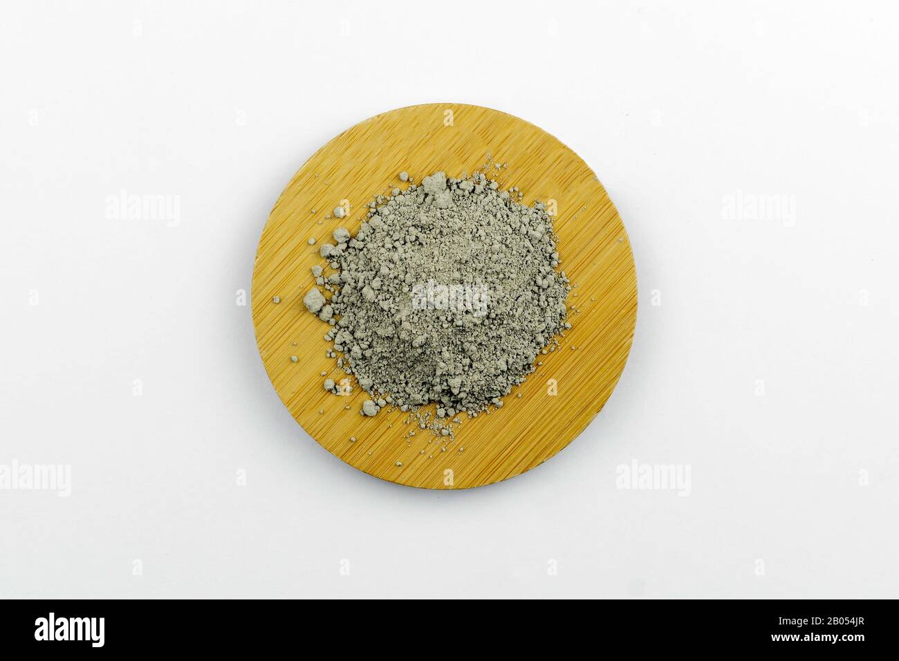 Close-up of a cosmetic dry green clay powder ion wooden round plate ...