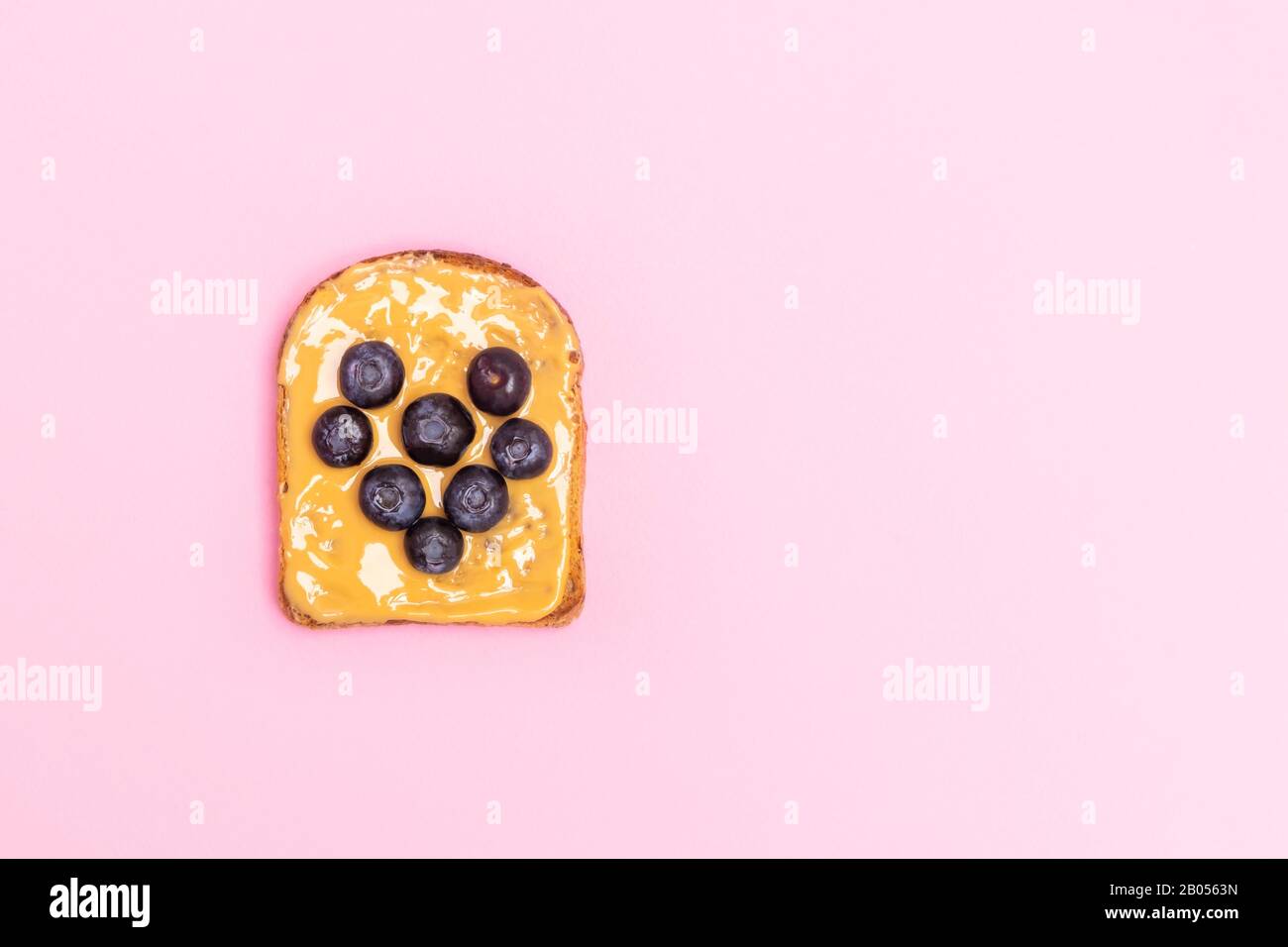 Above view of peanut butter toast with blueberry in heart shape for ...