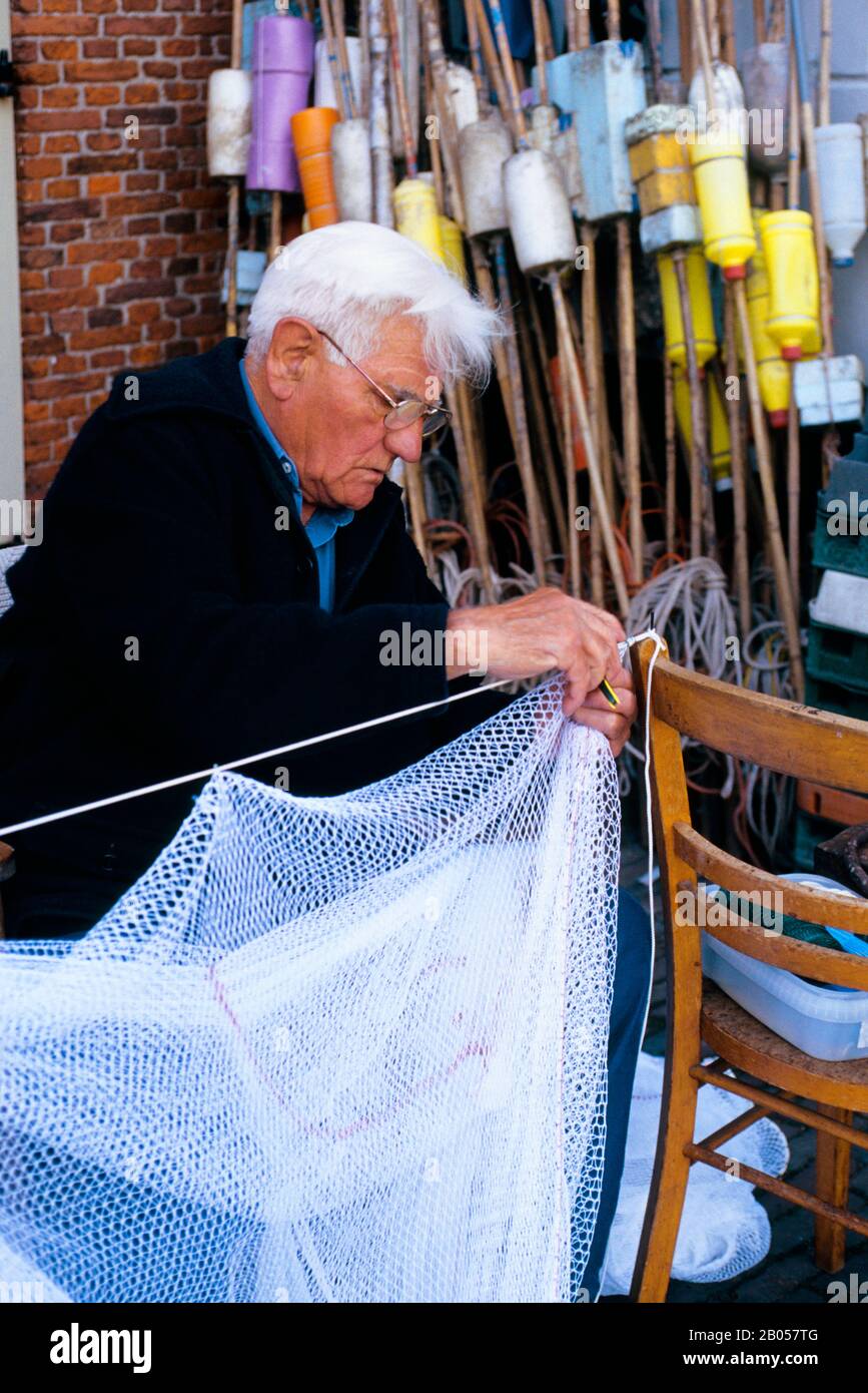 Local fisherman repairing nets hi-res stock photography and images - Alamy