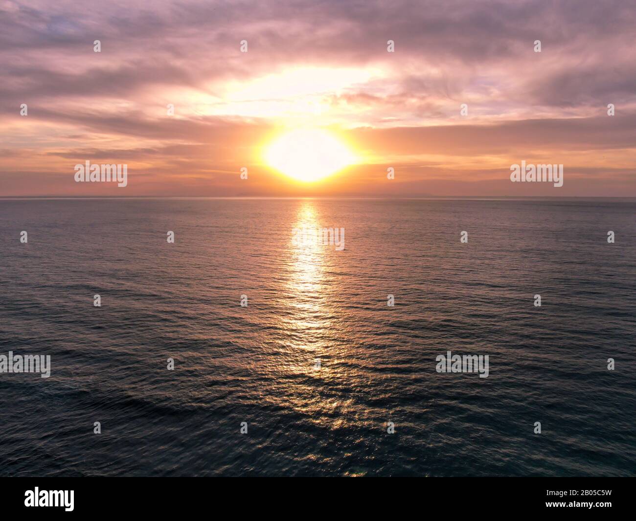 Aerial view of Pacific ocean colorful sunset, facing the sun with ...