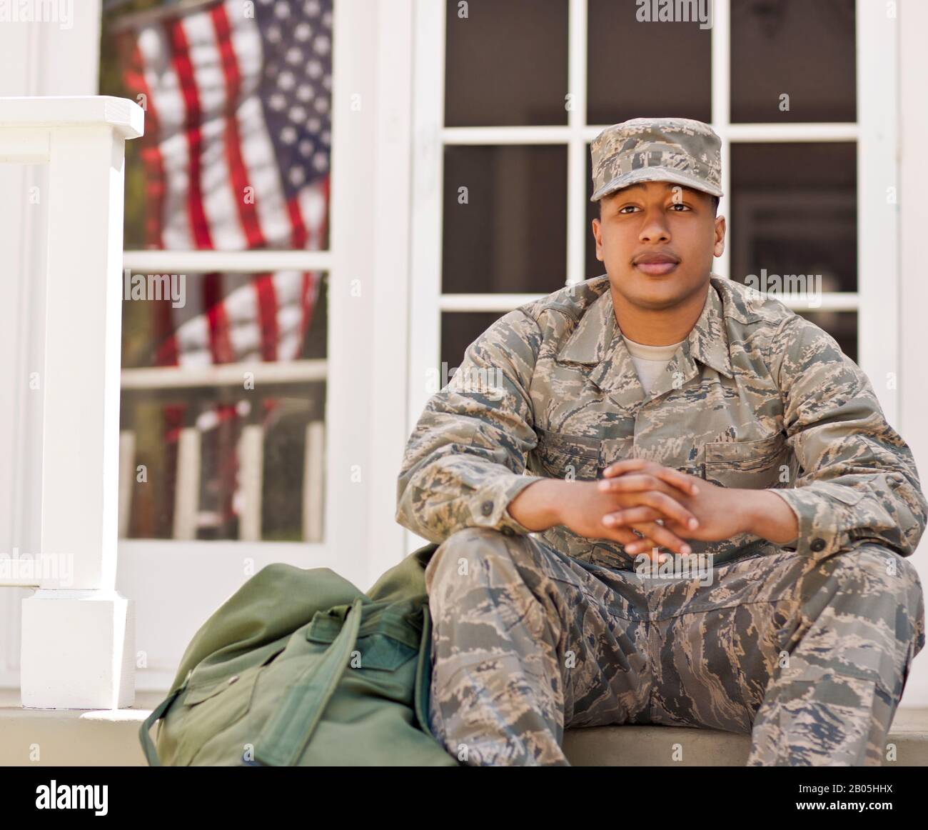 Young adult soldier sitting on the porch of his home Stock Photo - Alamy