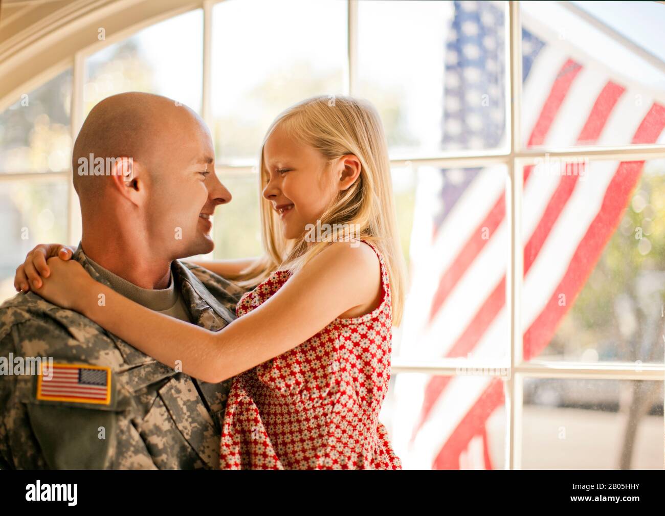 Happy soldier hugging his young daughter inside their home Stock Photo ...