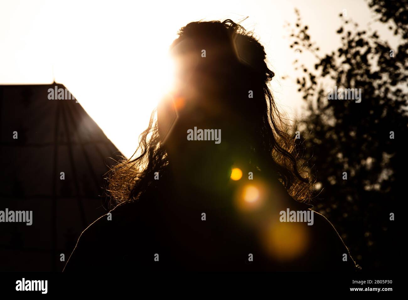 A close up abstract backlit view of a man facing the sun during golden ...