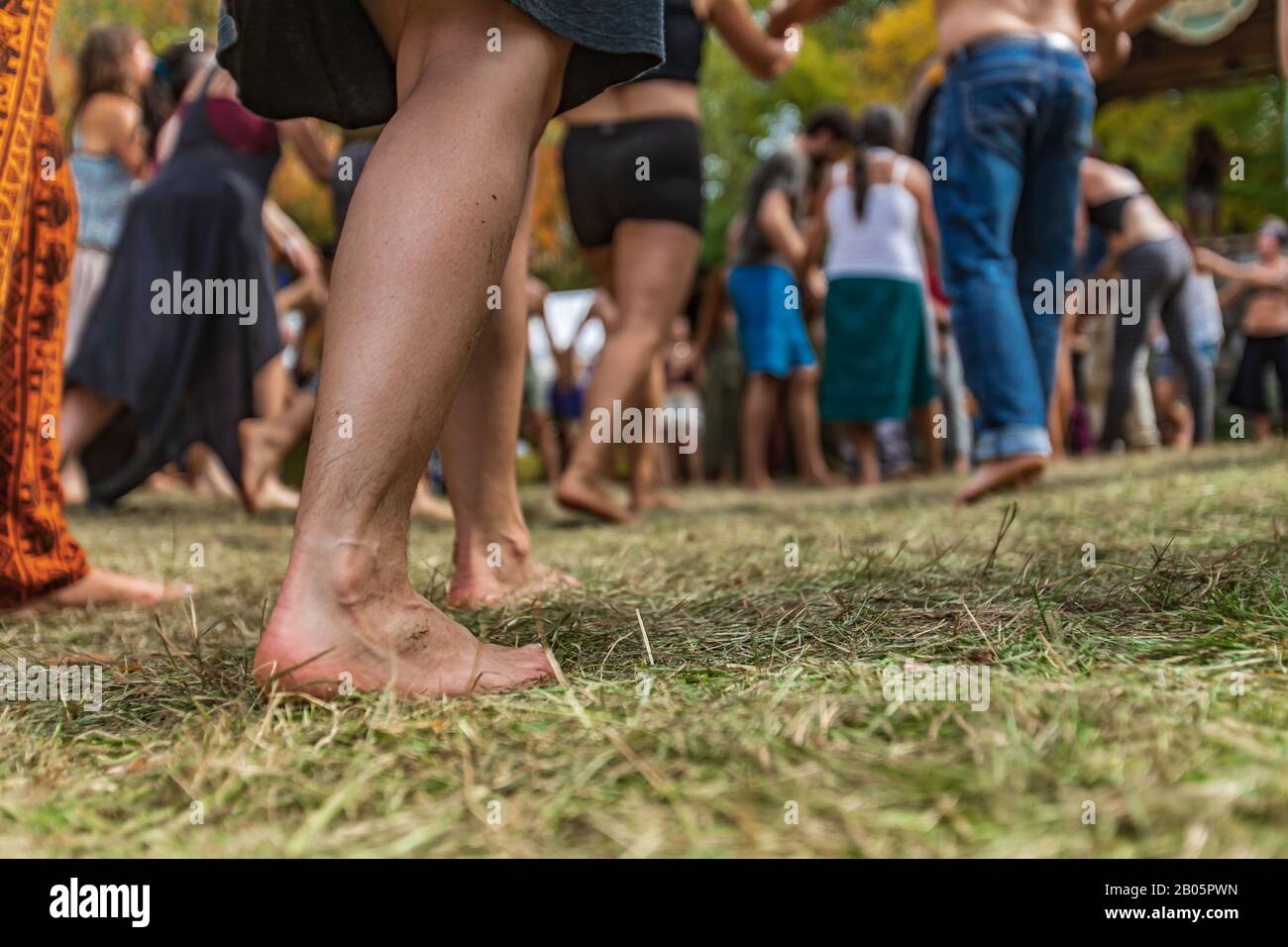 A ground level perspective on the legs of a diverse group of people ...