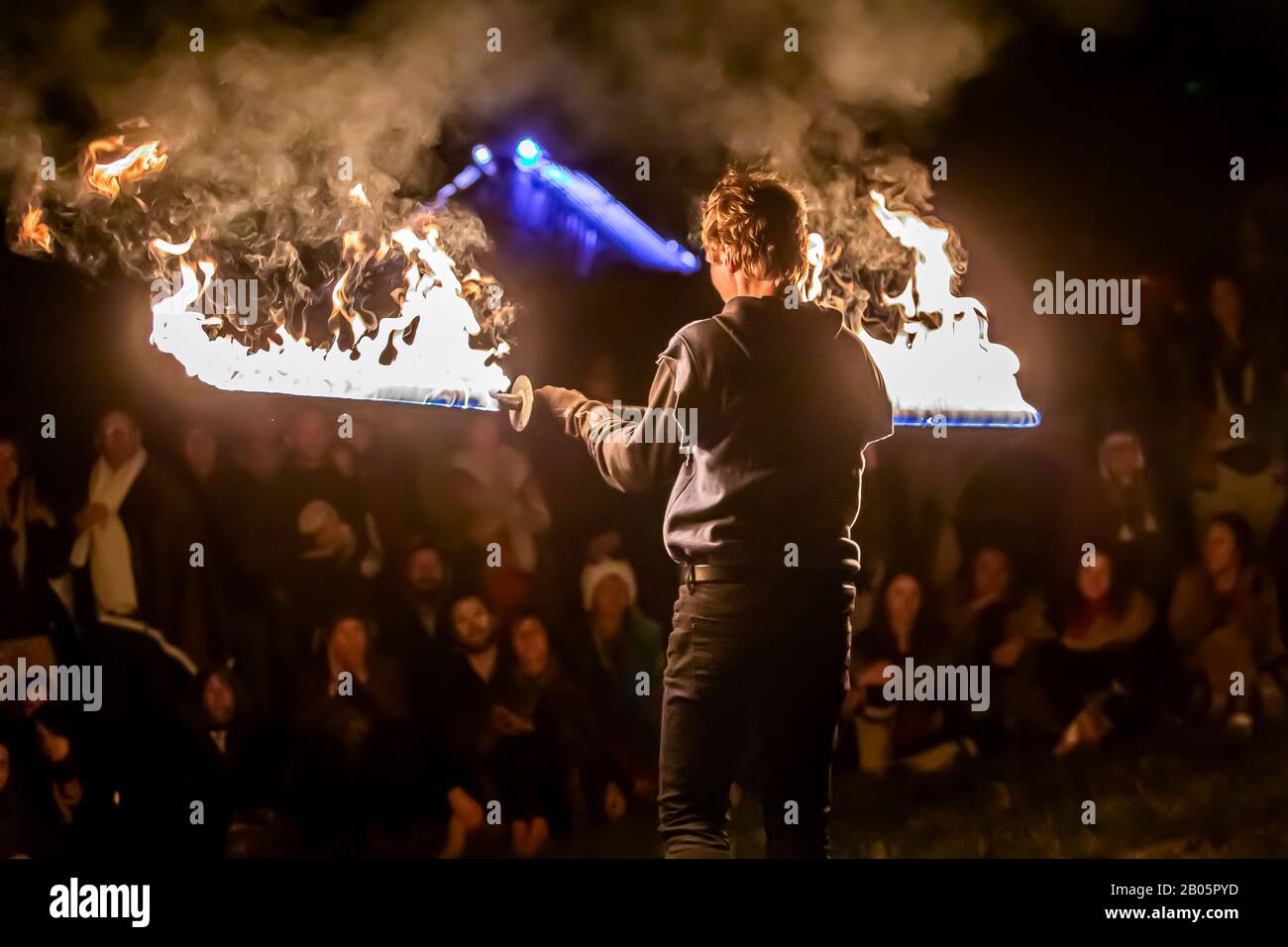 A man is seen holding burning swords during a fire dance routine by ...