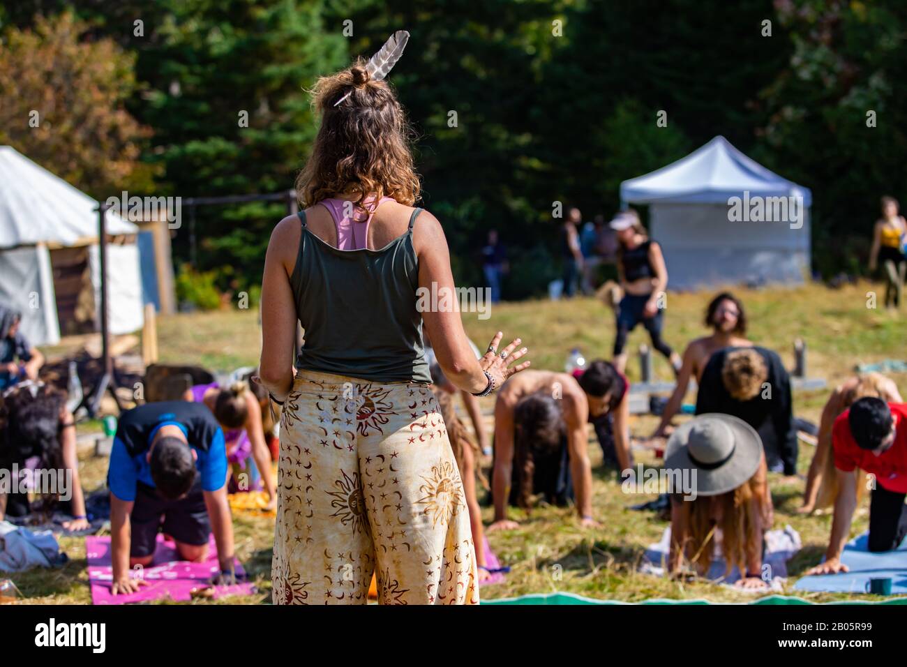 A spiritual guide is seen teaching people mindful yoga exercises in a ...