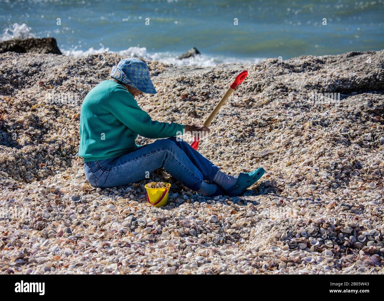 Woman on beach gathering sea shells, Sanibel Captiva, Island, Florida ...