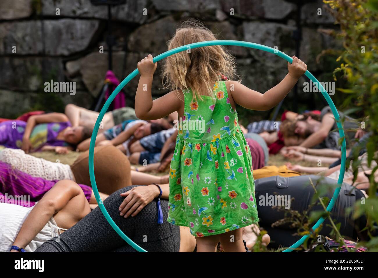 A cute and innocent child watches on as a group of adults practice ...