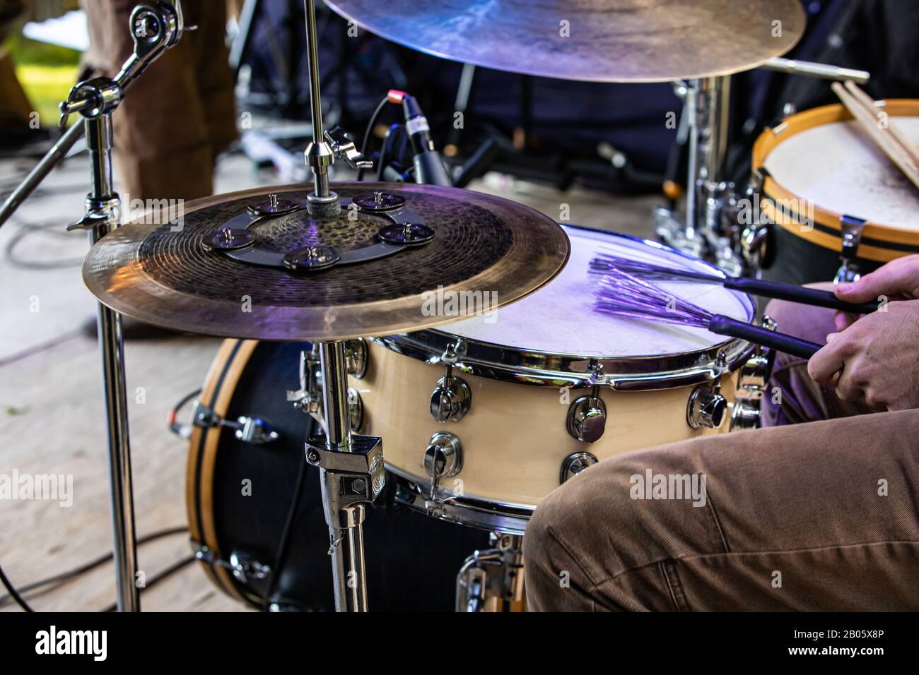 A close up view of a drum kit and the legs and hands of a drummer ...