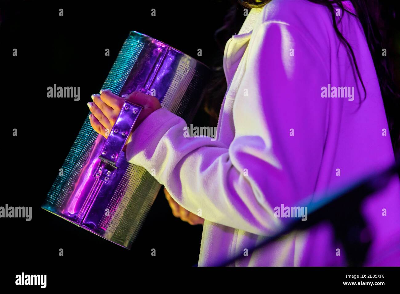A close up and side view of a musician using a metal tin can made into ...