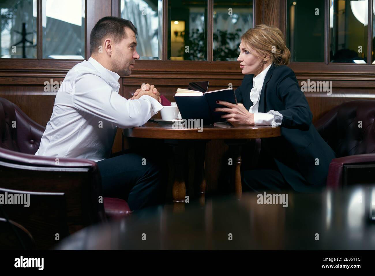 Business people talking over coffee in a cafe Stock Photo - Alamy