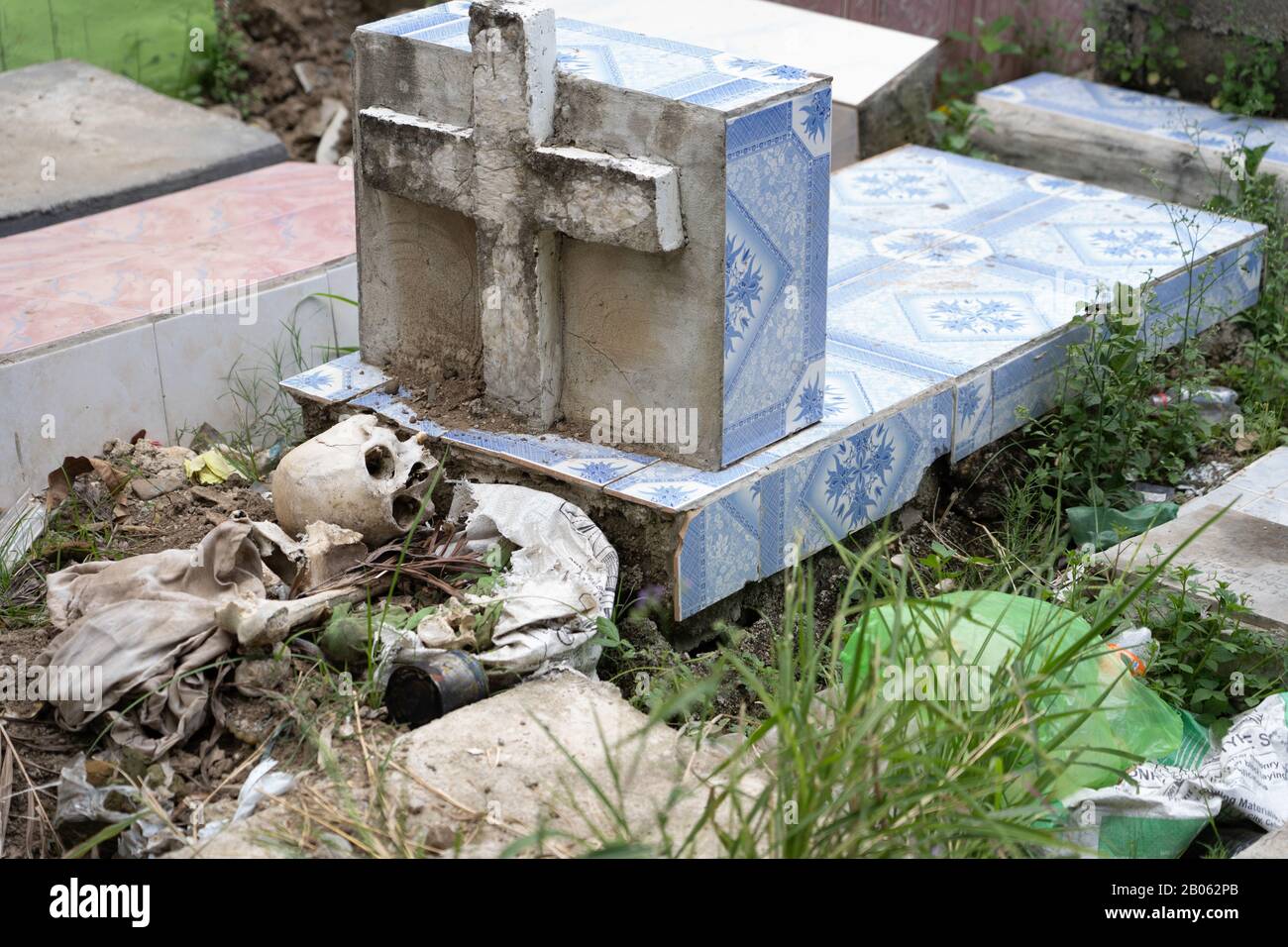 A human skull and bones resting on the ledge of a tomb within Calamba ...