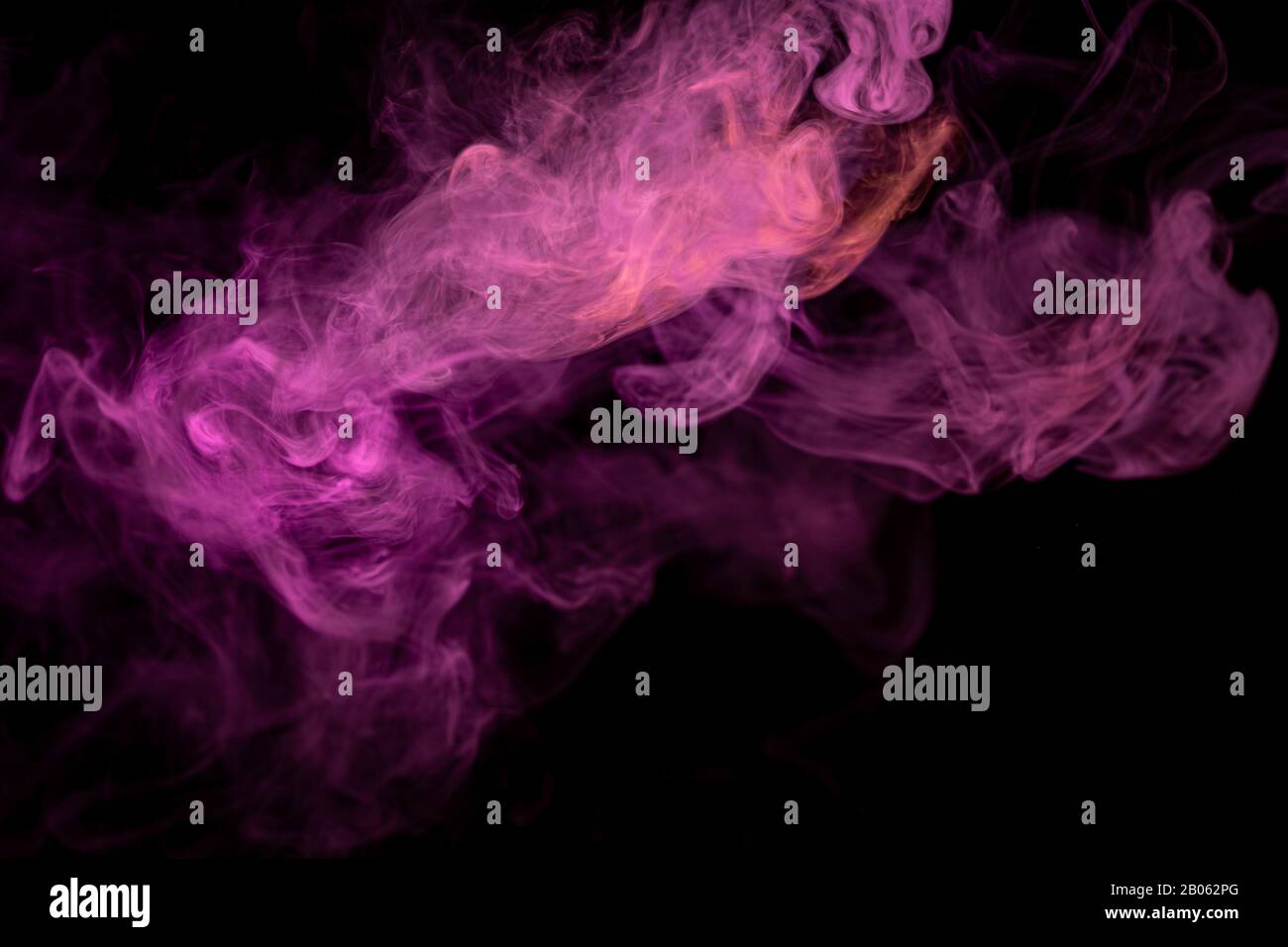 Thick colorful smoke of red and pink on a black isolated background ...
