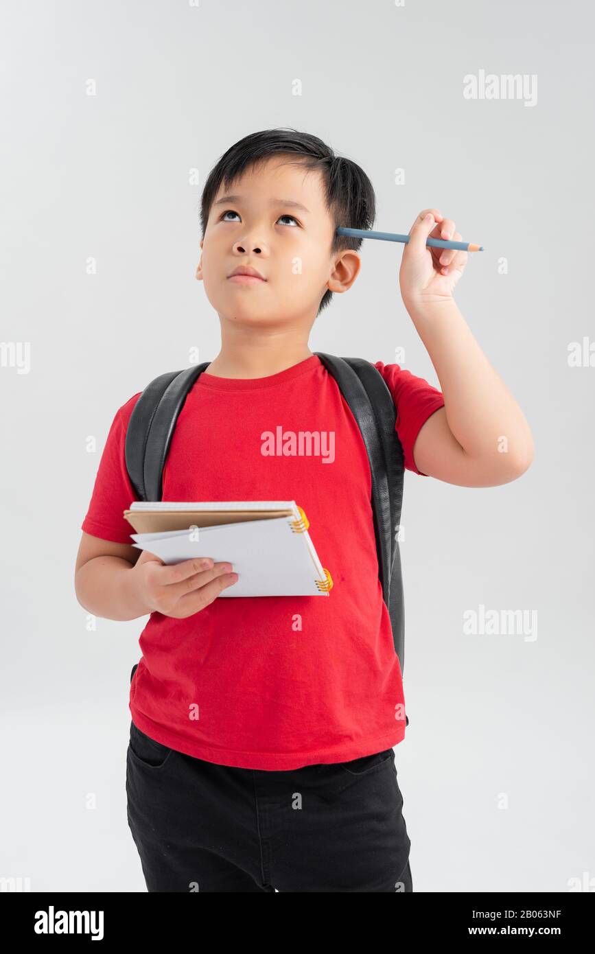 Image of sad smarty boy wearing backpack thinking and touching temple ...