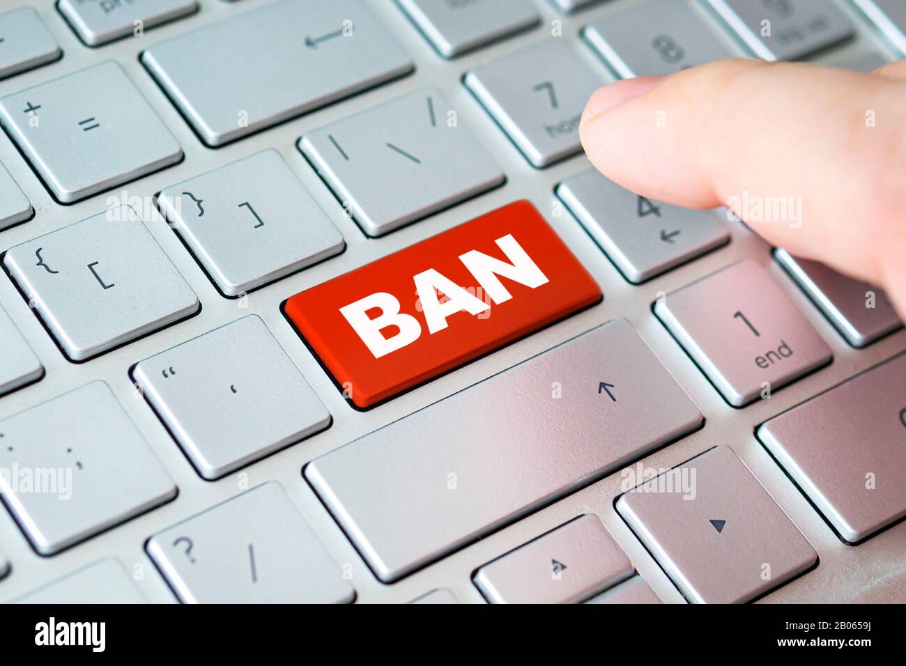 Closed up finger on keyboard with word BAN. The concept of lock ...