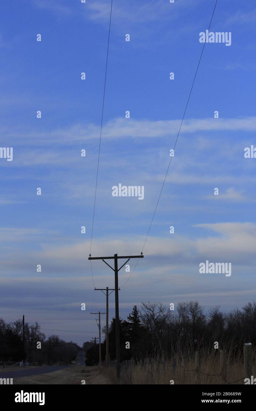 Power lines out in the country with blue sky and tree's in Kansas Stock ...