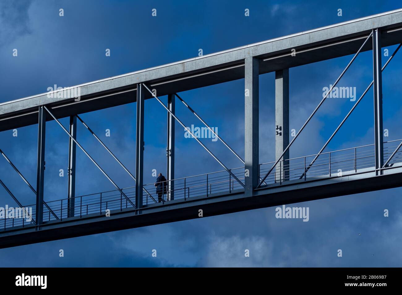 Bridge City Man Crossing infront of blue sky Stock Photo - Alamy