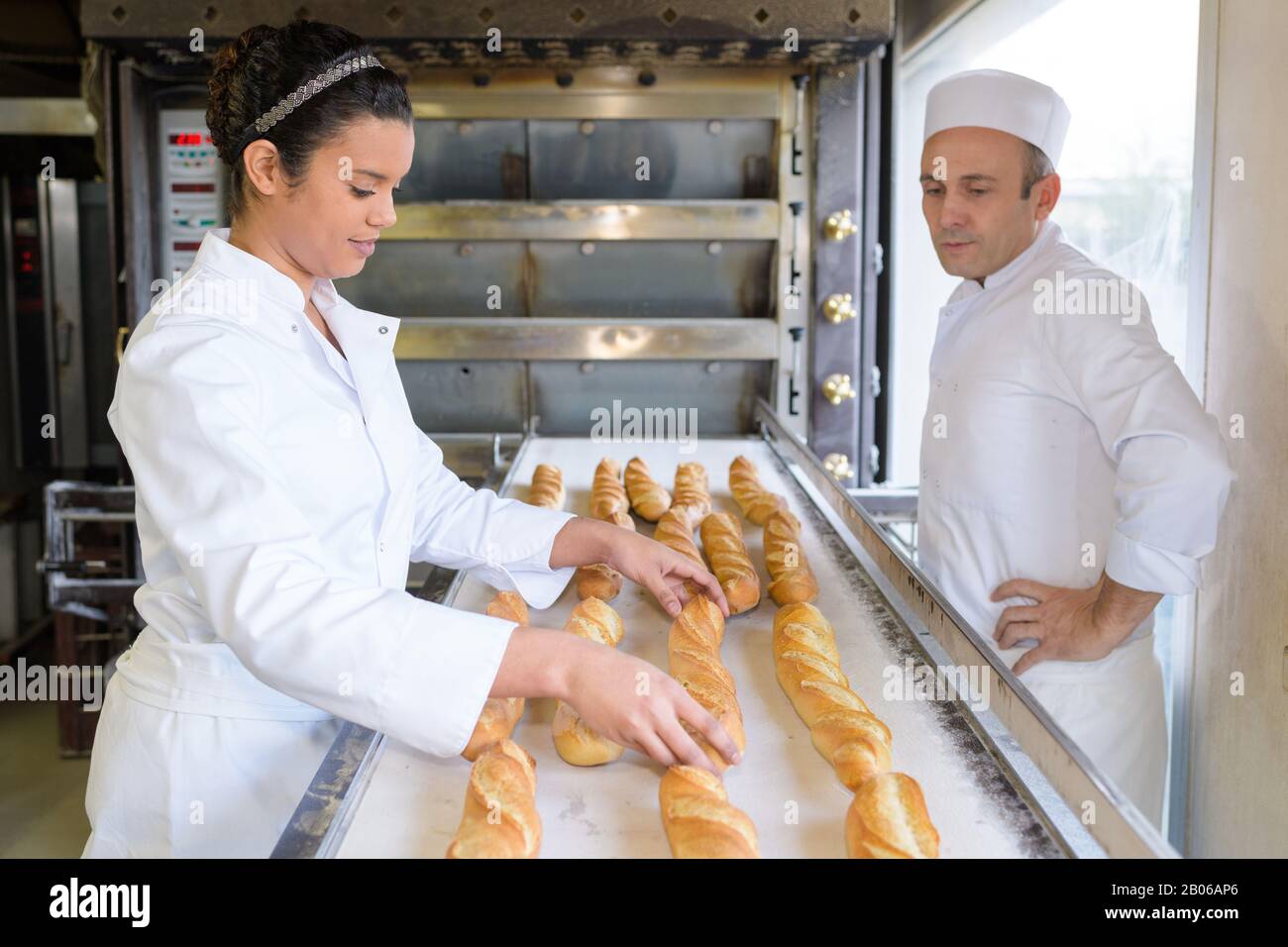 female baker positioning the bread Stock Photo - Alamy
