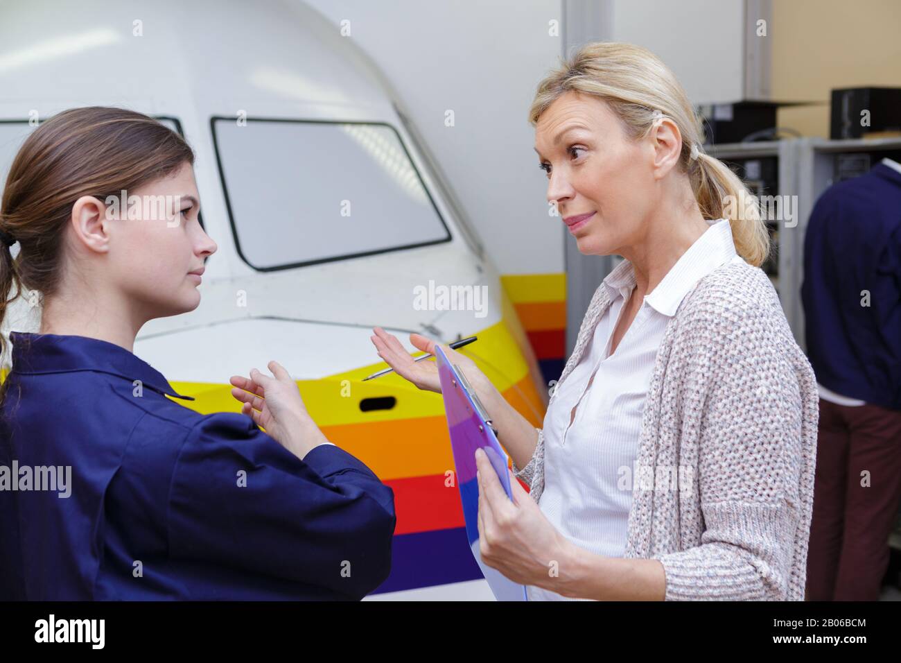 female engineers talking about airplane Stock Photo - Alamy