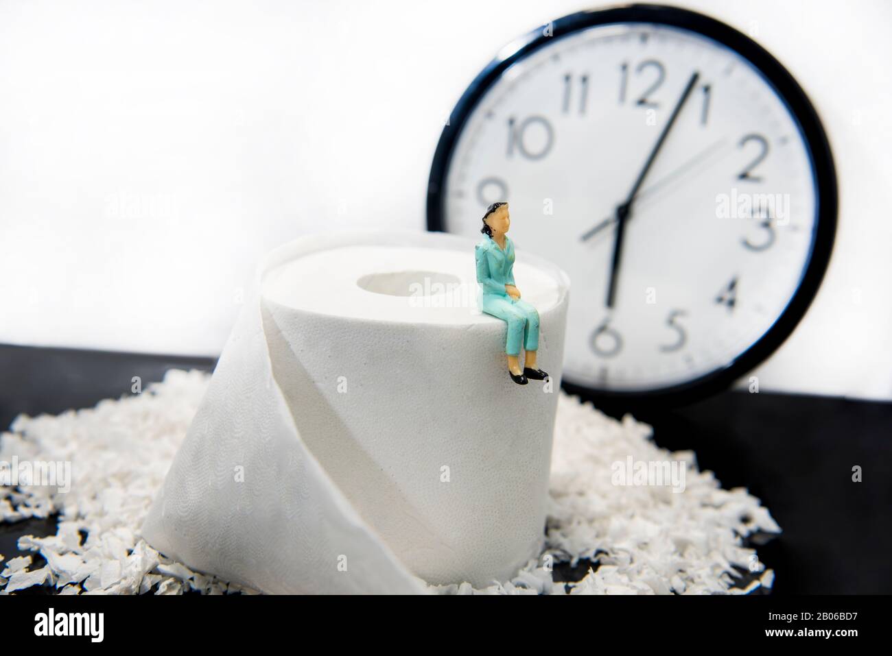 Abstract photo with toilet paper and some small people figures. Waste ...