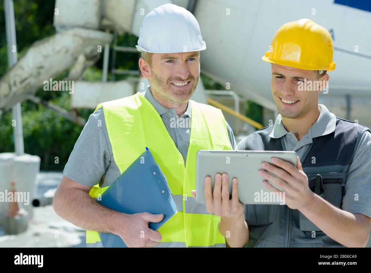 the two men in helmets talking outside factory Stock Photo - Alamy