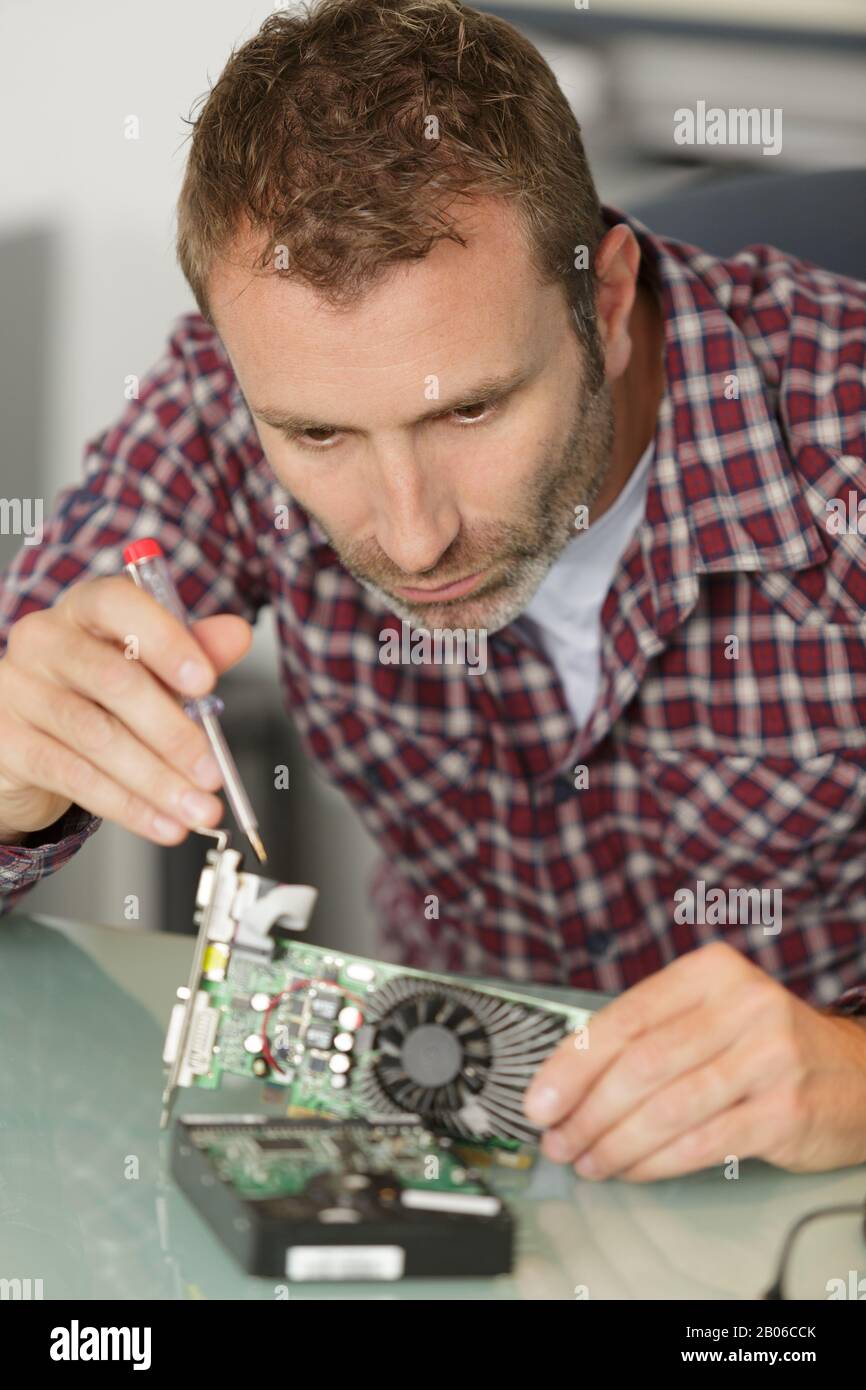 man is repairing broken pc with a screw driver Stock Photo - Alamy