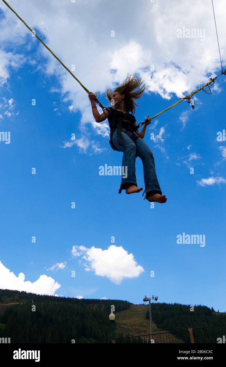 USA, IDAHO, NEAR SANDPOINT, SCHWEITZER MOUNTAIN RESORT, TEENAGER BUNGEE ...