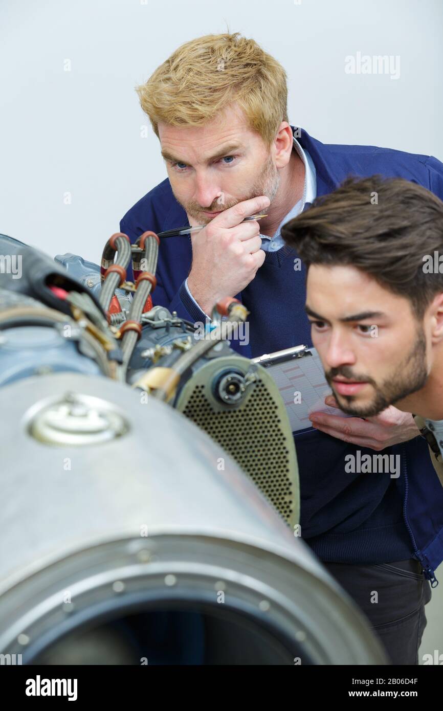 2 mechanic men fixing an engine Stock Photo - Alamy