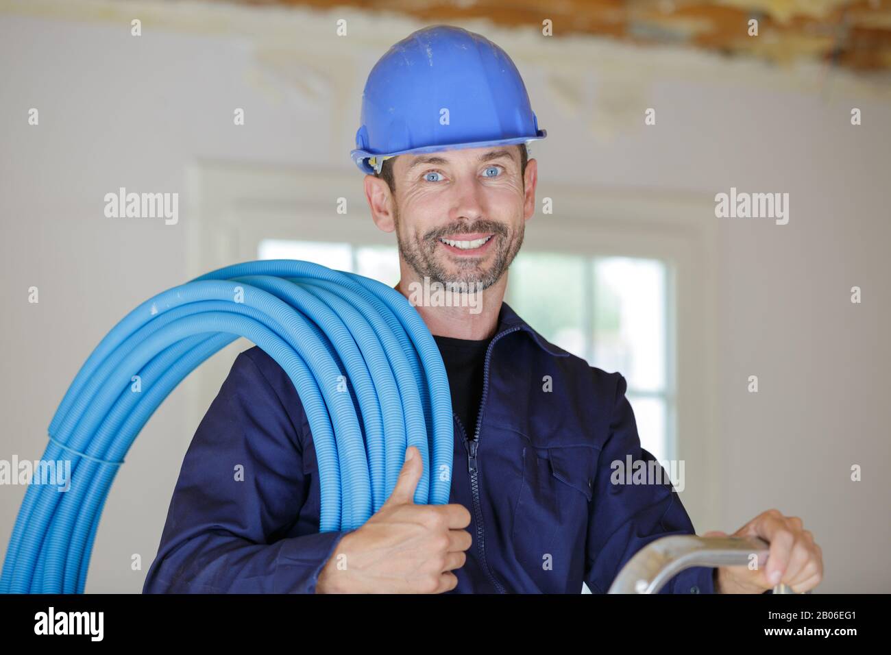 smiling man holding cables showing thumb up sign Stock Photo - Alamy
