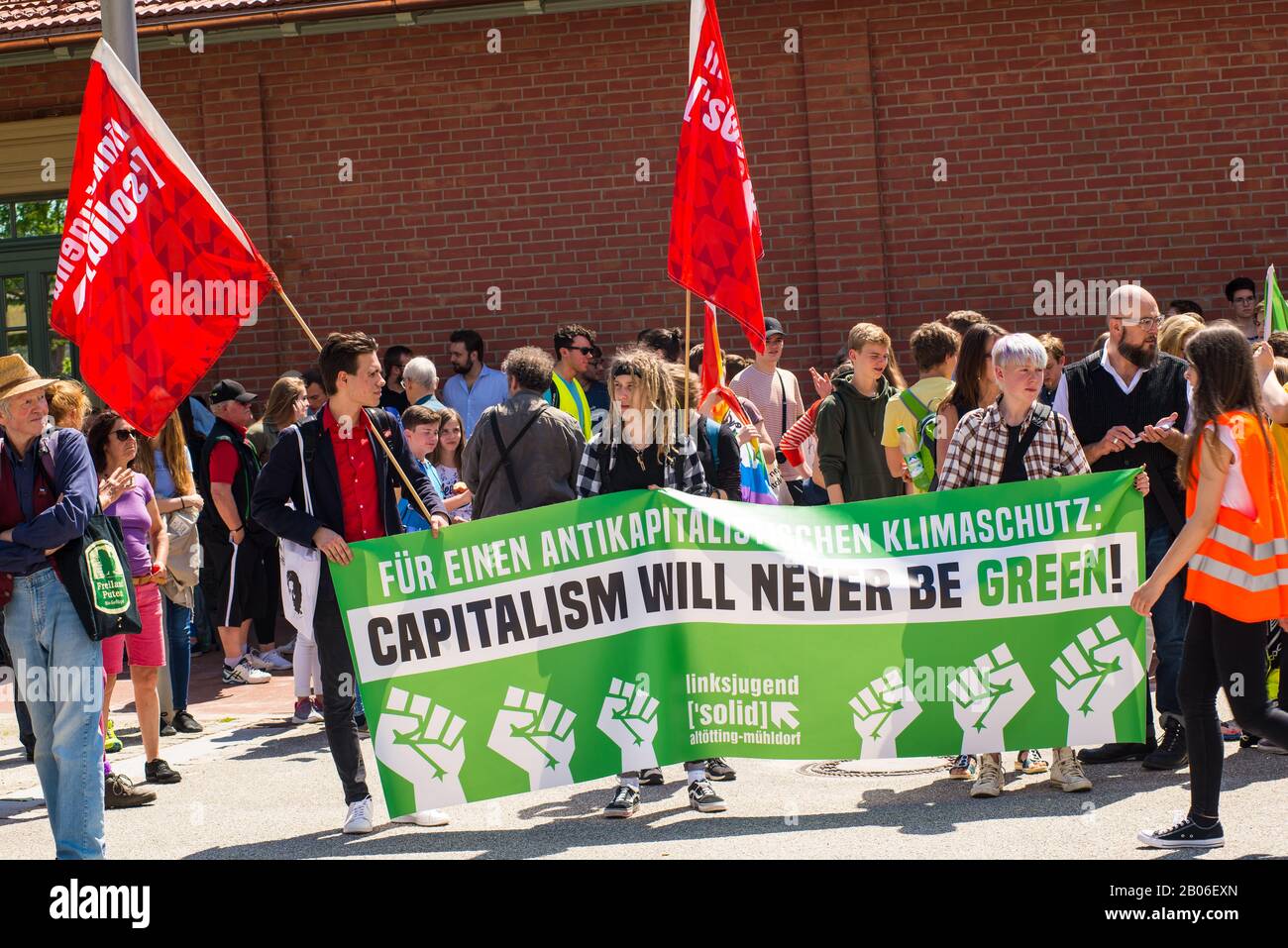 A group of young people hold different signs protesting against ...