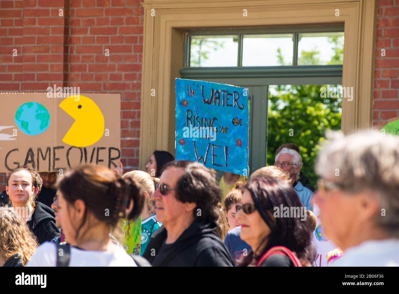 Protesters hold signs against climate change at the start of the rally ...