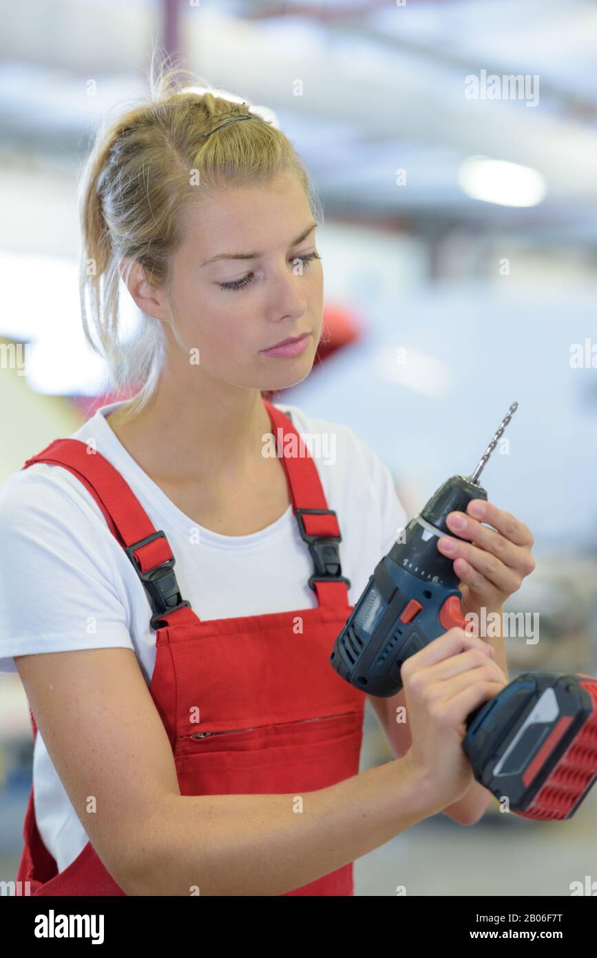cute woman at work using drilling machine Stock Photo - Alamy