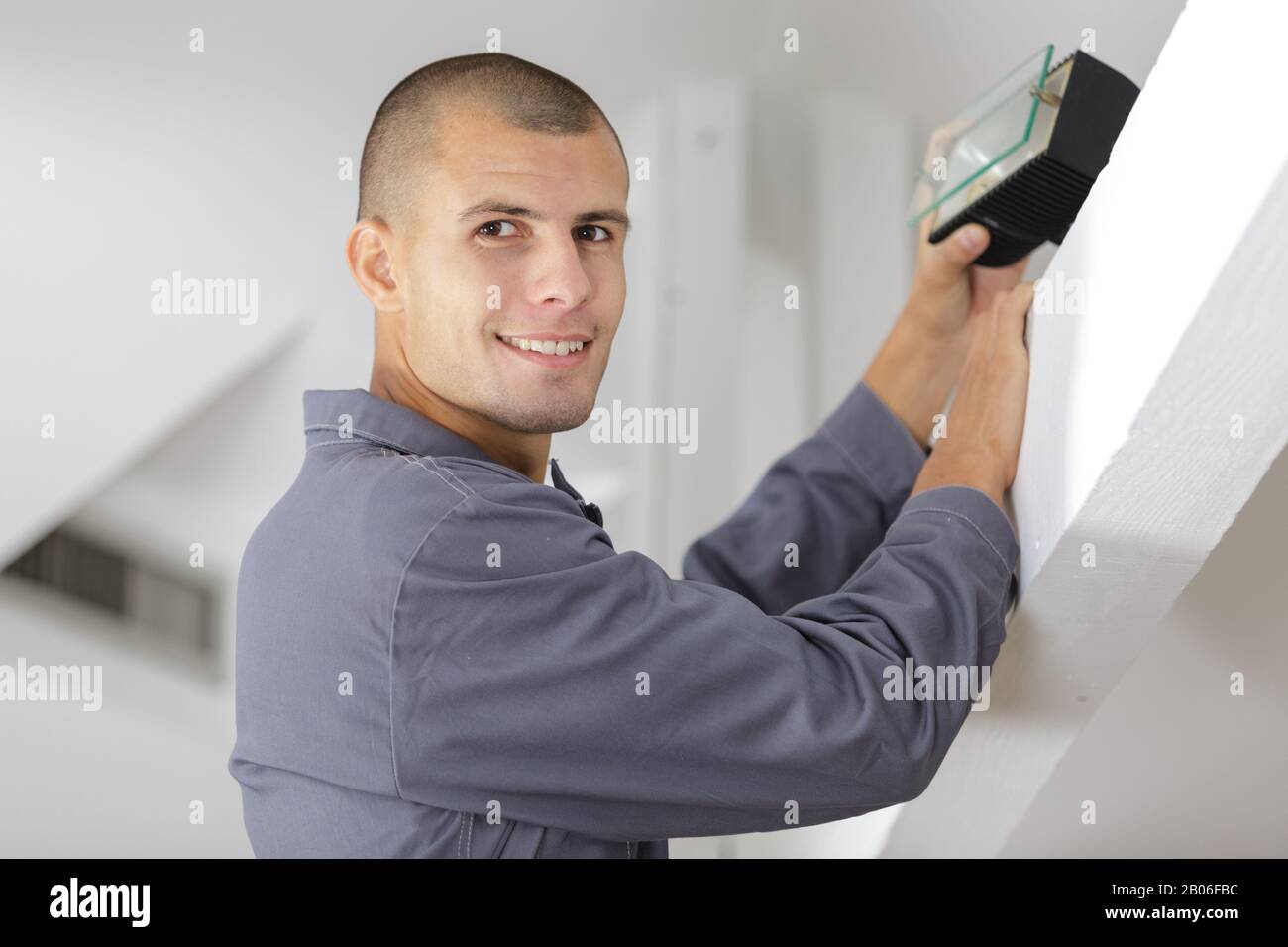 man repairing a house on a light Stock Photo - Alamy