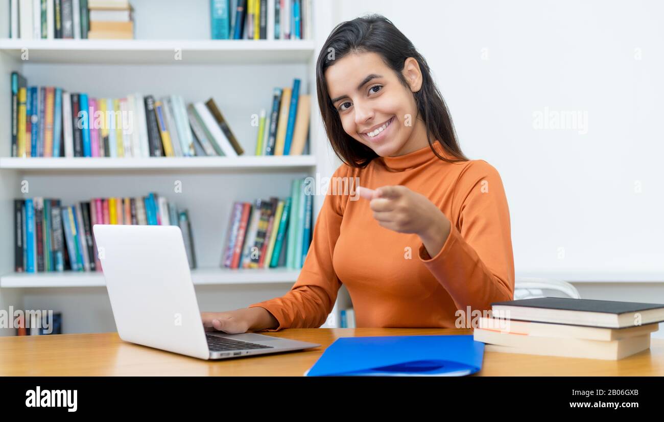 Laughing turkish female student learning at computer isolated on white ...