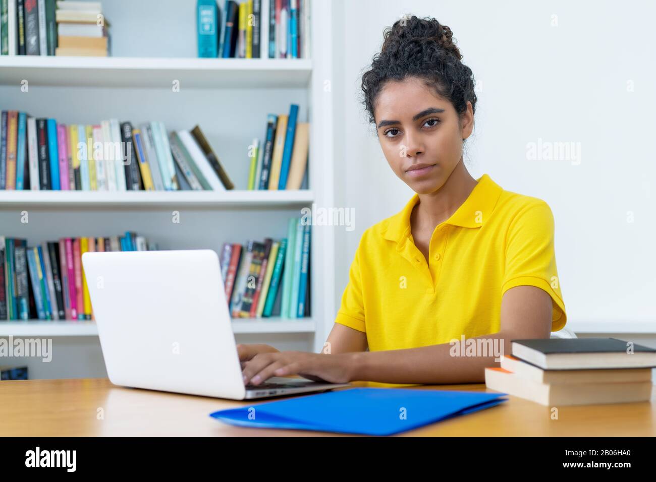Beautiful brazilian female student learning at computer at university ...