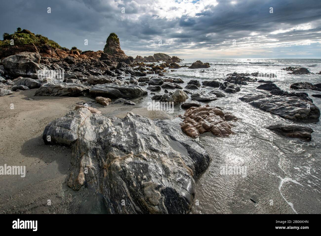 Rocky coast, rocks on the beach, dark rain clouds, long time exposure ...