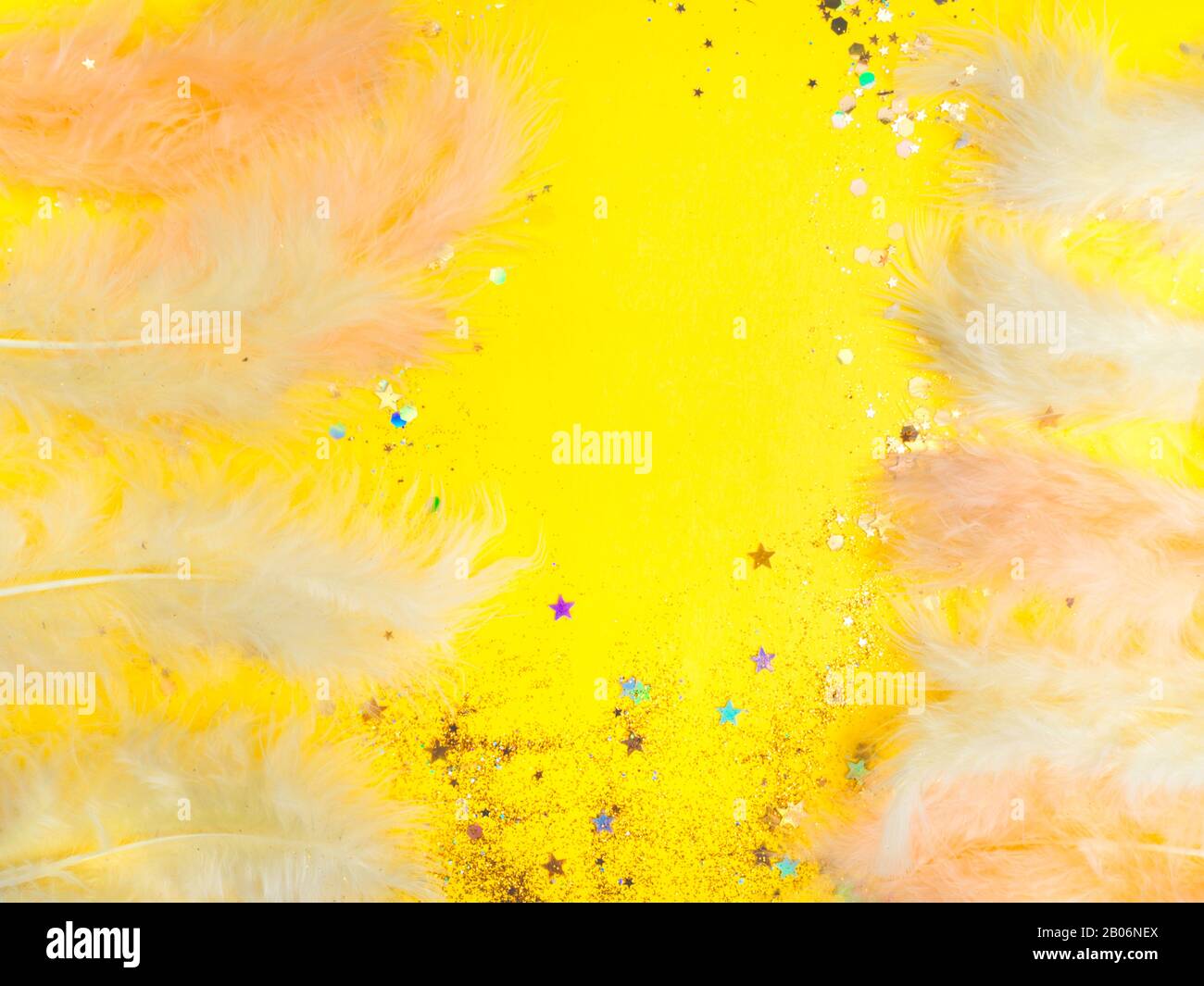 Easter yellow festive background with beautiful feathers, glitters ...