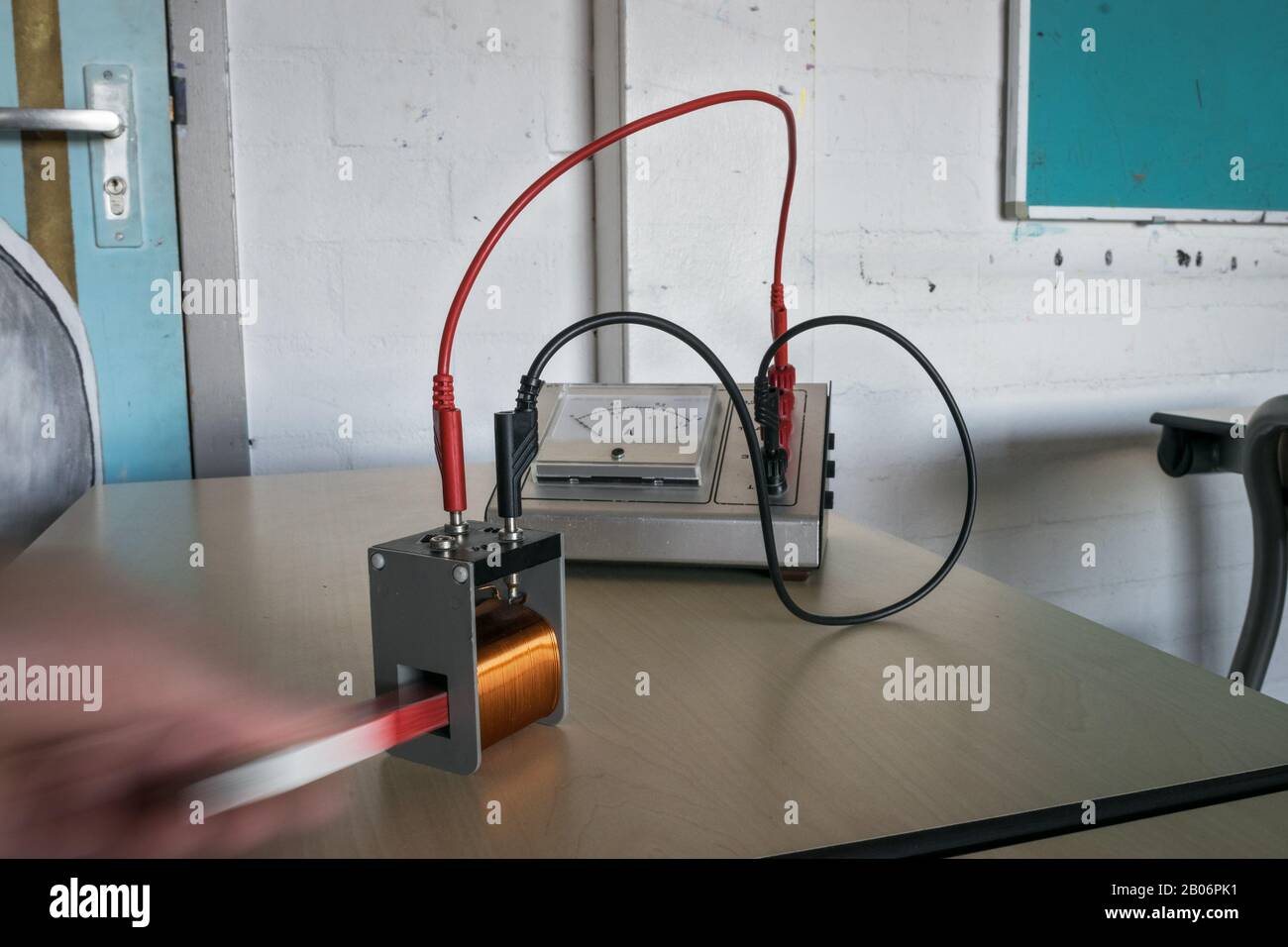 Magnet is moved back and forth through a copper coil, inducing an ...