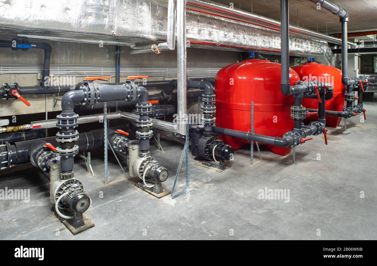 Interior of modern boiler room. Piping system. Large red boiler units ...