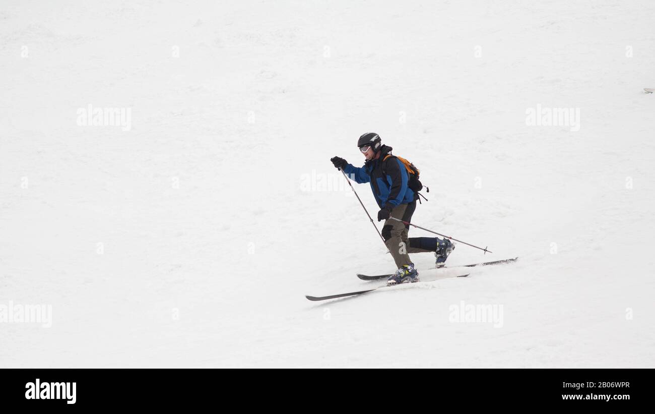 Ski resort. The skier quickly rides down a snow-covered professional ...