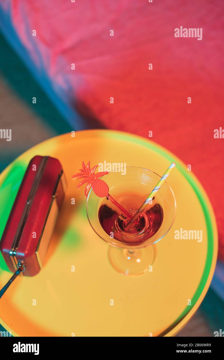 Yellow table with cocktail drink and portable radio next to sunbed ...
