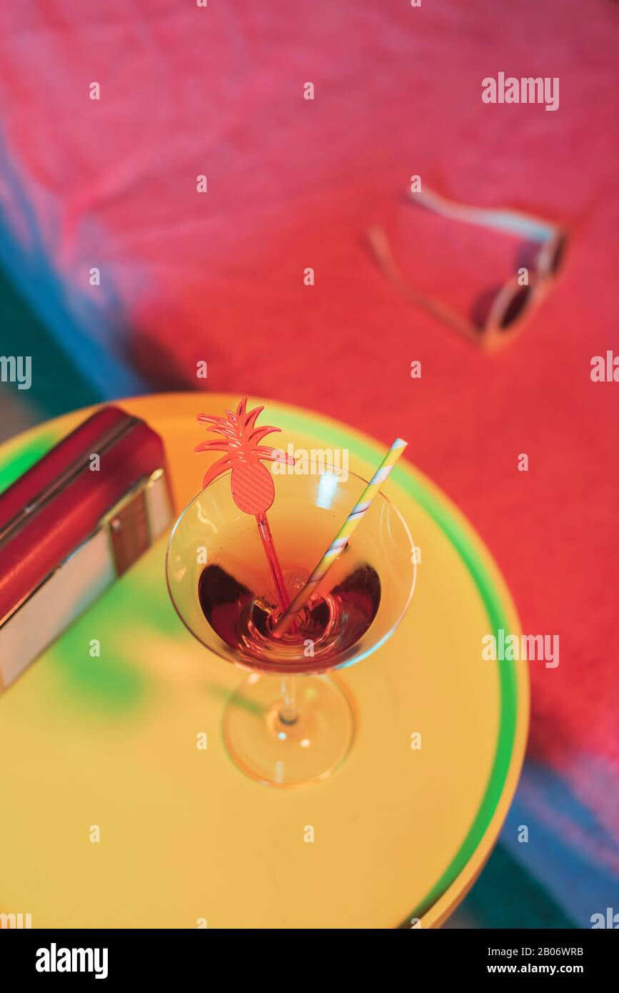 Yellow table with cocktail drink and portable radio next to sunbed ...