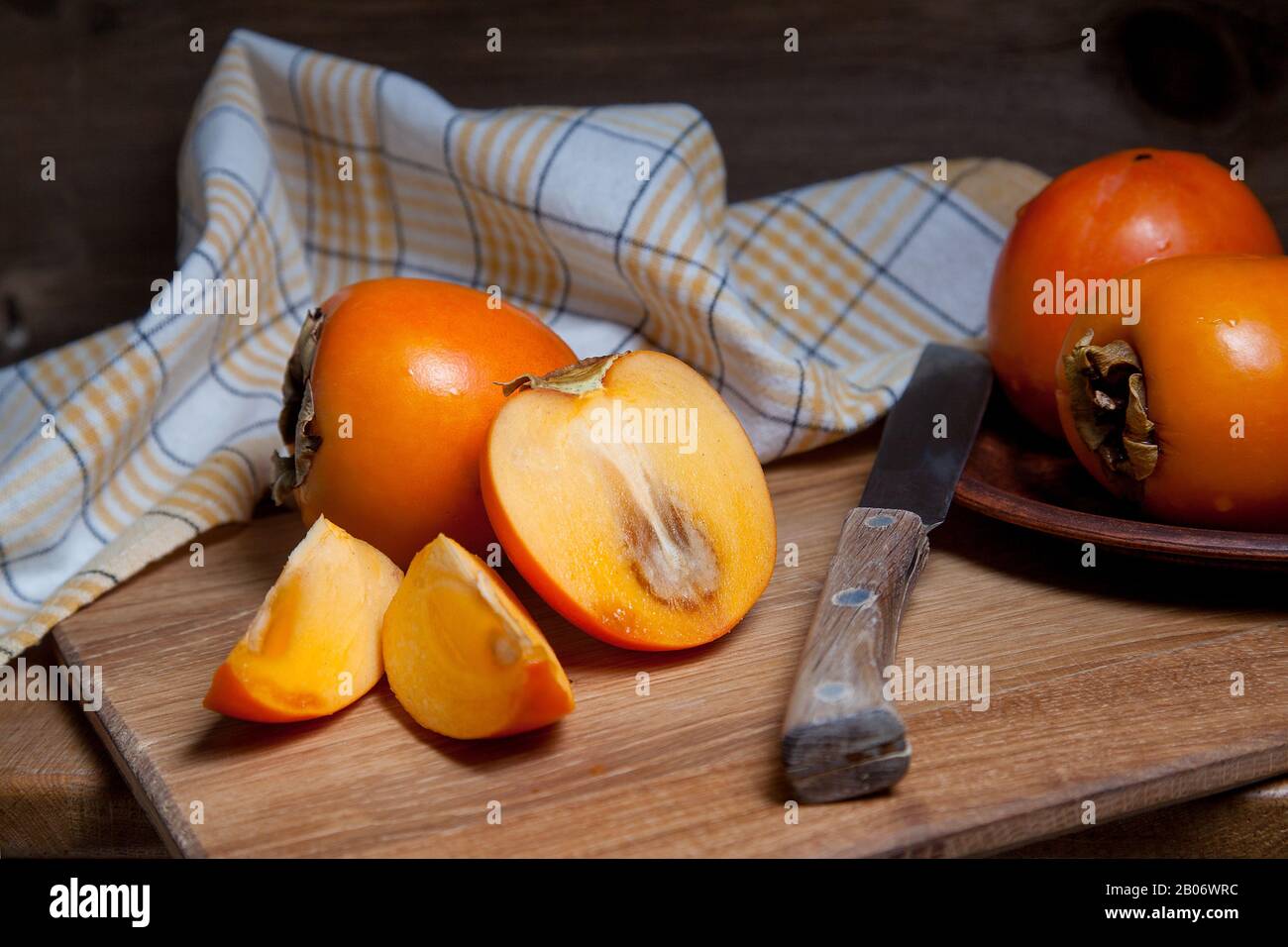 Composition of ripe delicious whole persimmon fruits, half and sliced ...