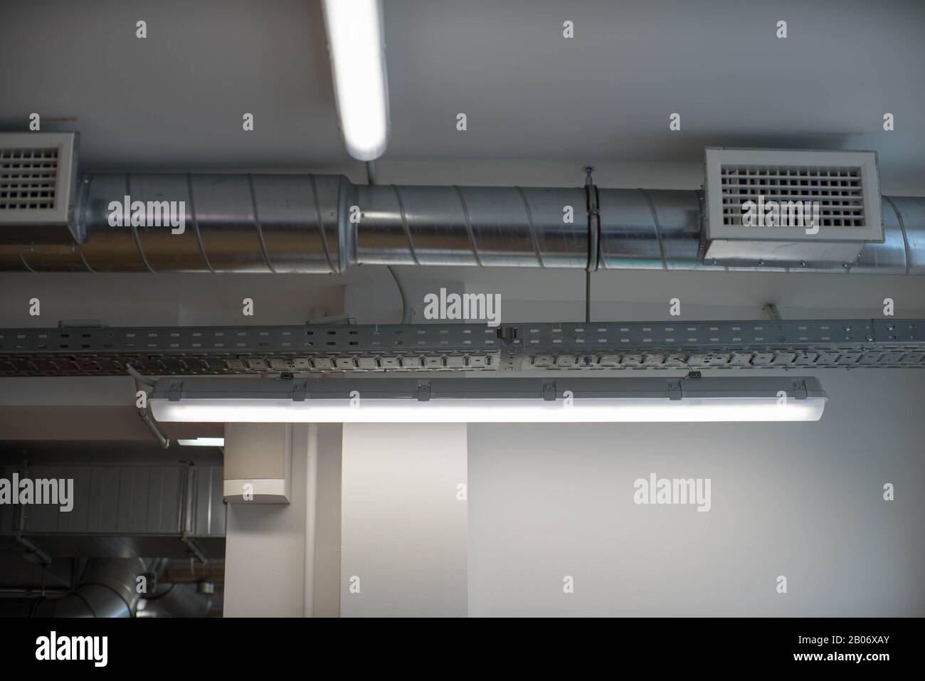 Metal pipe of ventilation system. Fluorescent lamp Stock Photo - Alamy