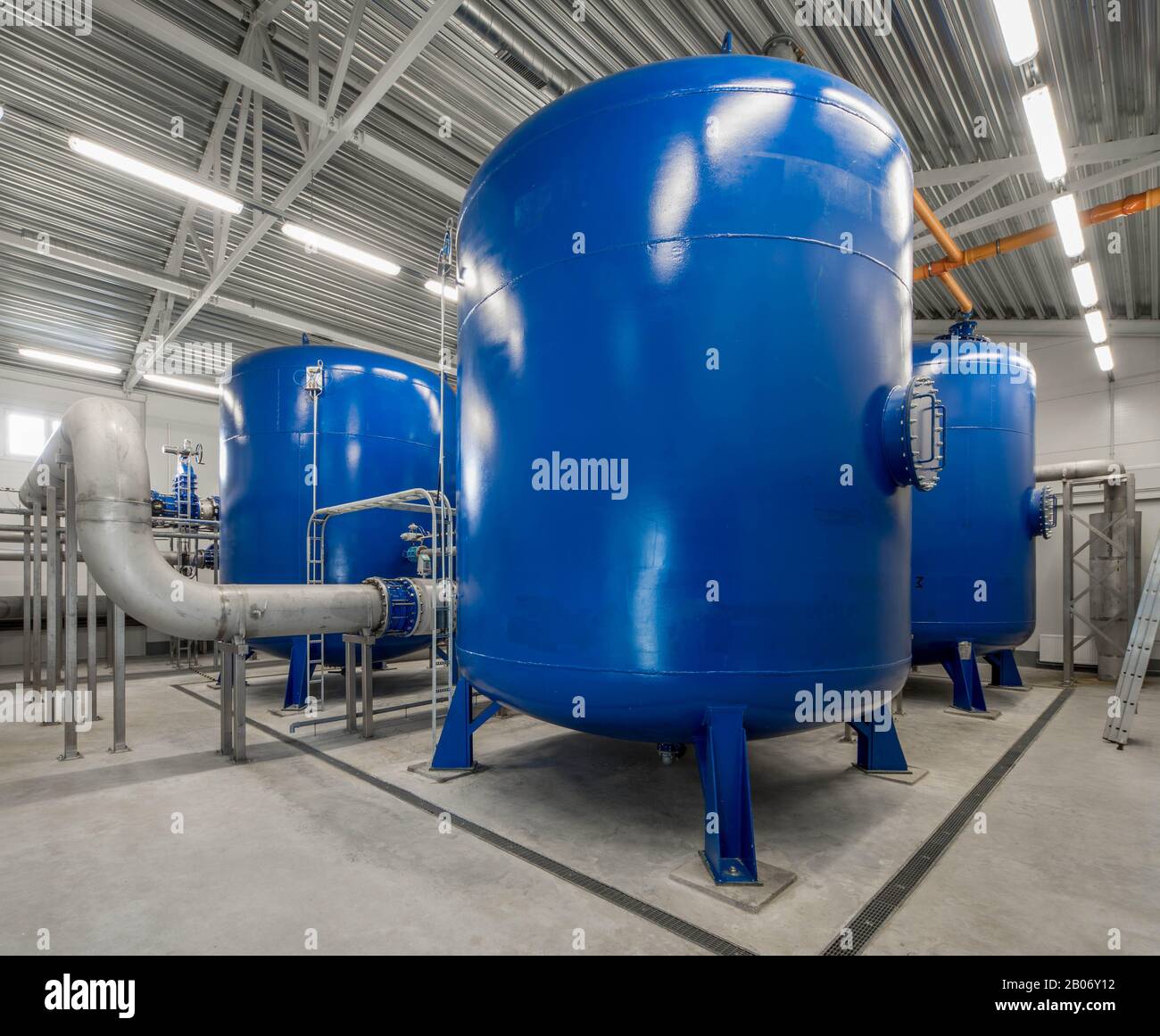 Interior of modern boiler room. Piping system. Large blue boiler units ...