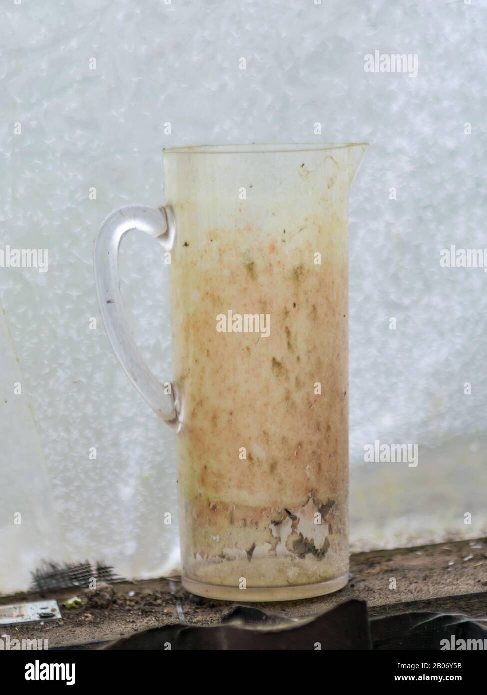 old and dirty light plastic mug, blurry background Stock Photo - Alamy