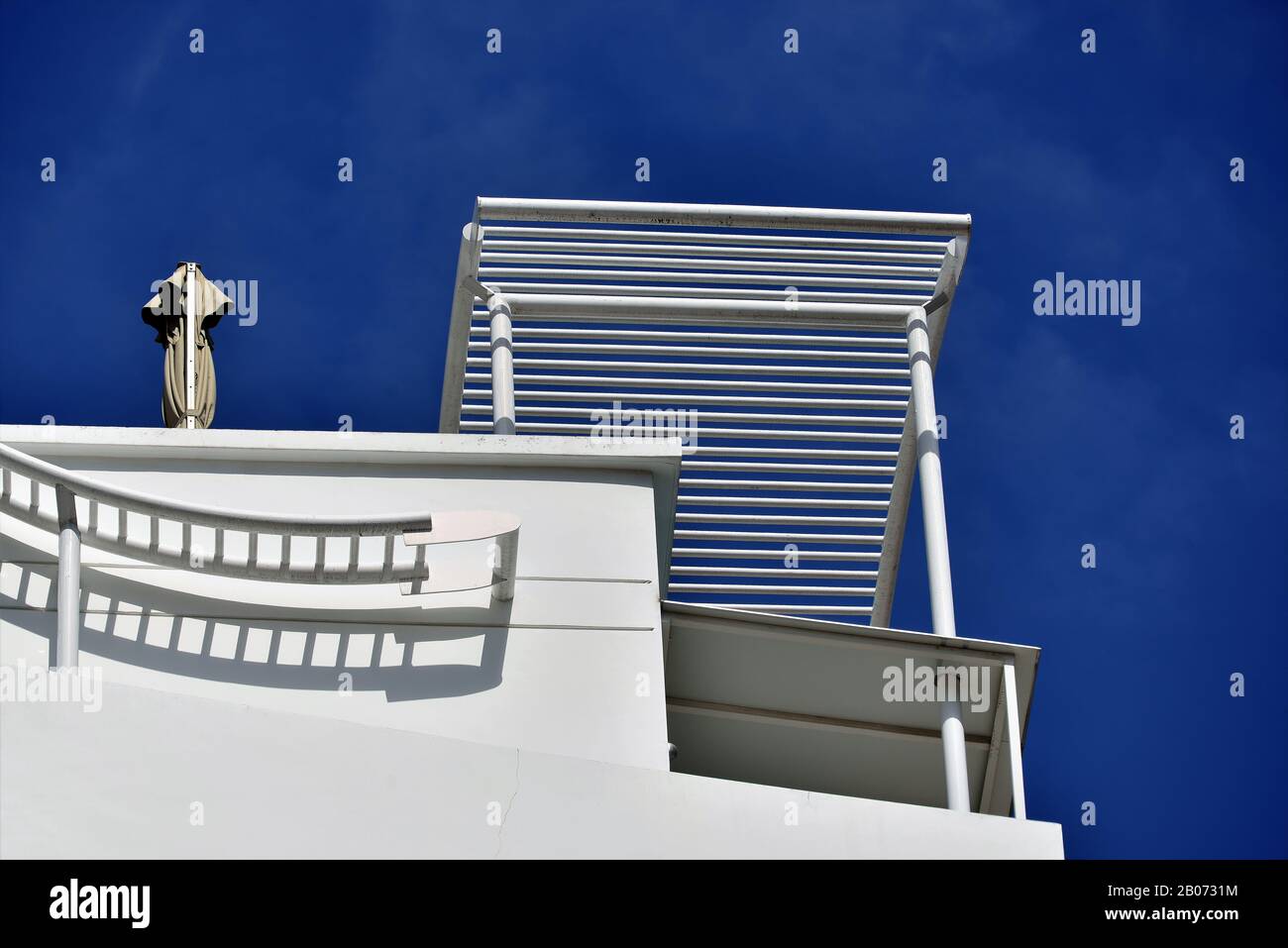 White modern roof and balcony isolated against blue sky in East Coast ...