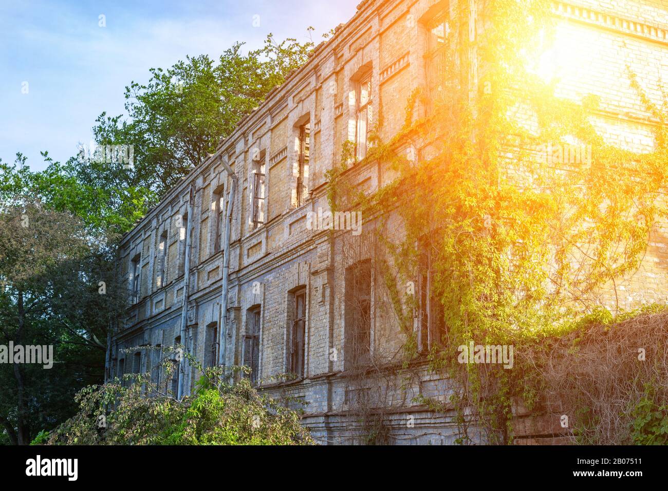 Old aged ruined abandoned two-storied brick building facade with ...