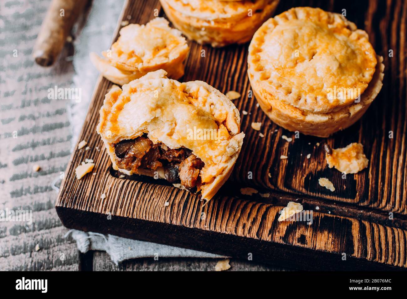 Fresh Traditional Australian meat mini pie on the wooden board on table ...