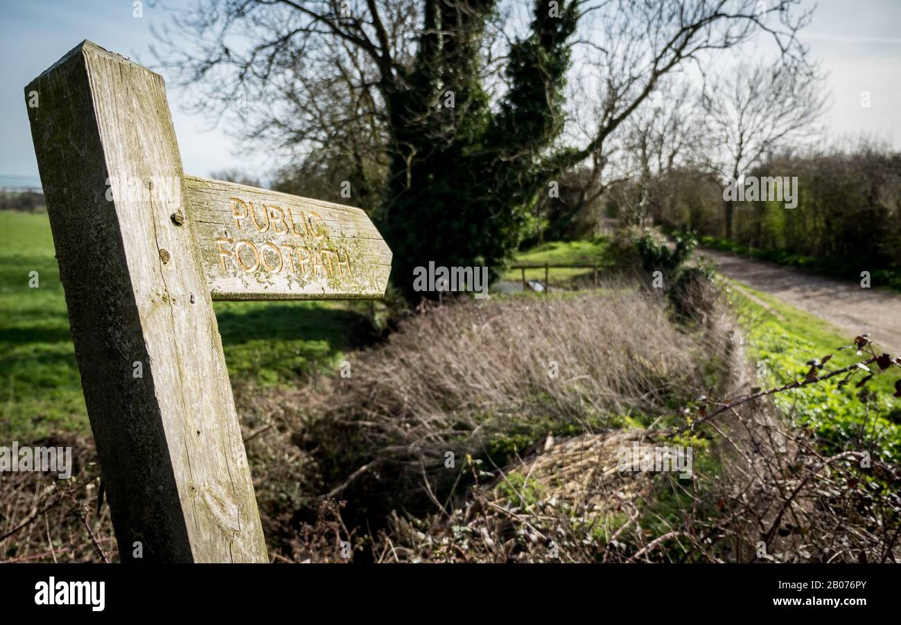 English countryside public footpath sign. A crooked sign covered in ...